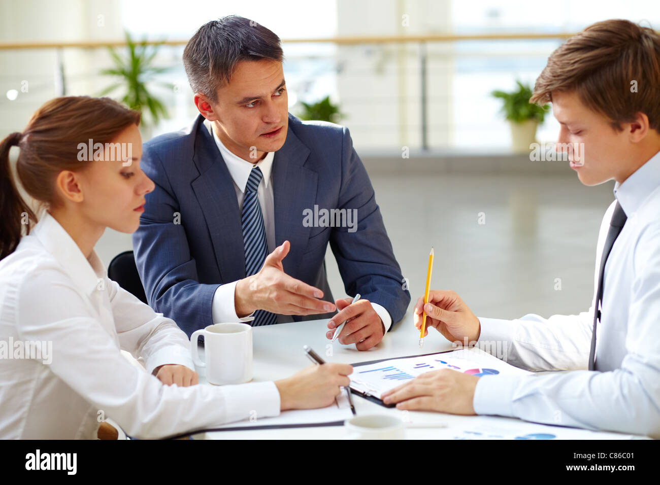 Young office worker reporting to his boss about work Stock Photo - Alamy