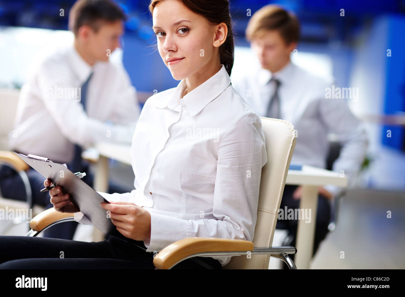 Portrait of young secretary sitting in office and smiling Stock Photo ...