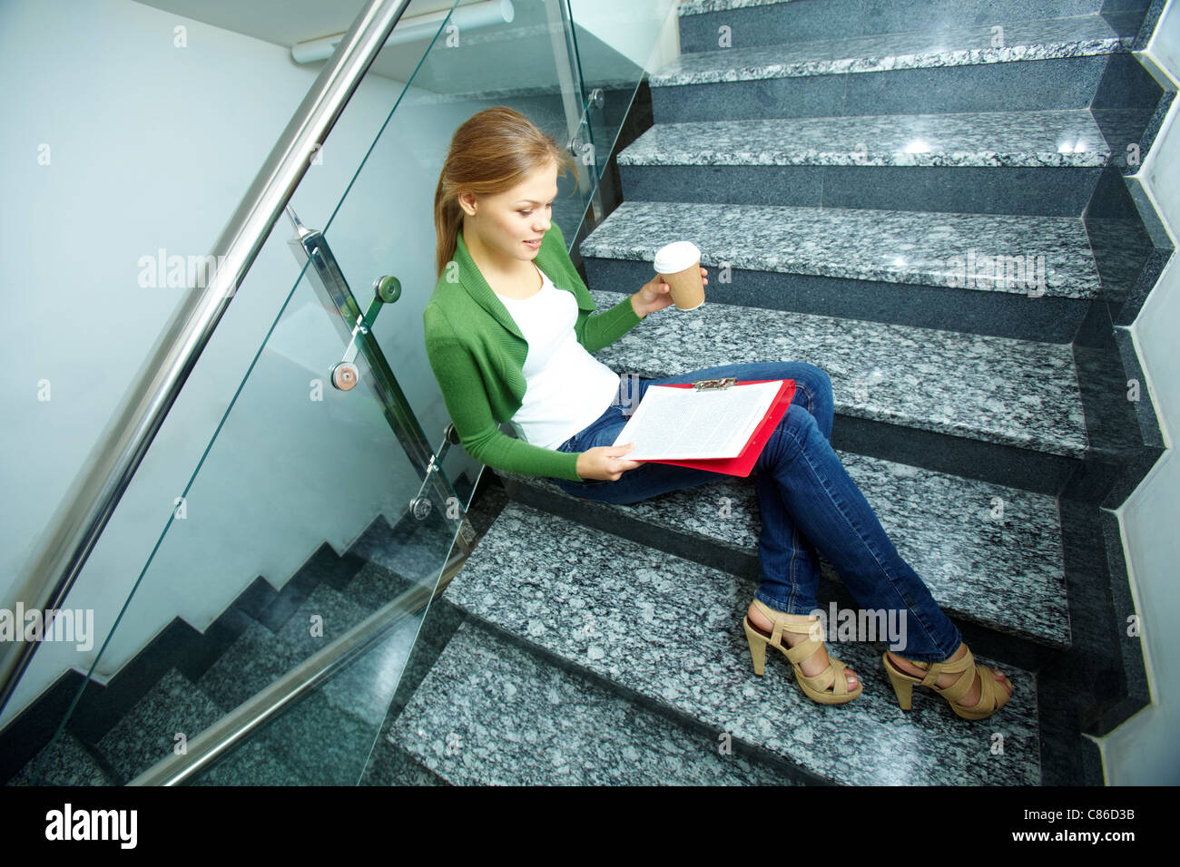 Photo of pretty girl with coffee reading paper on stairs of college ...