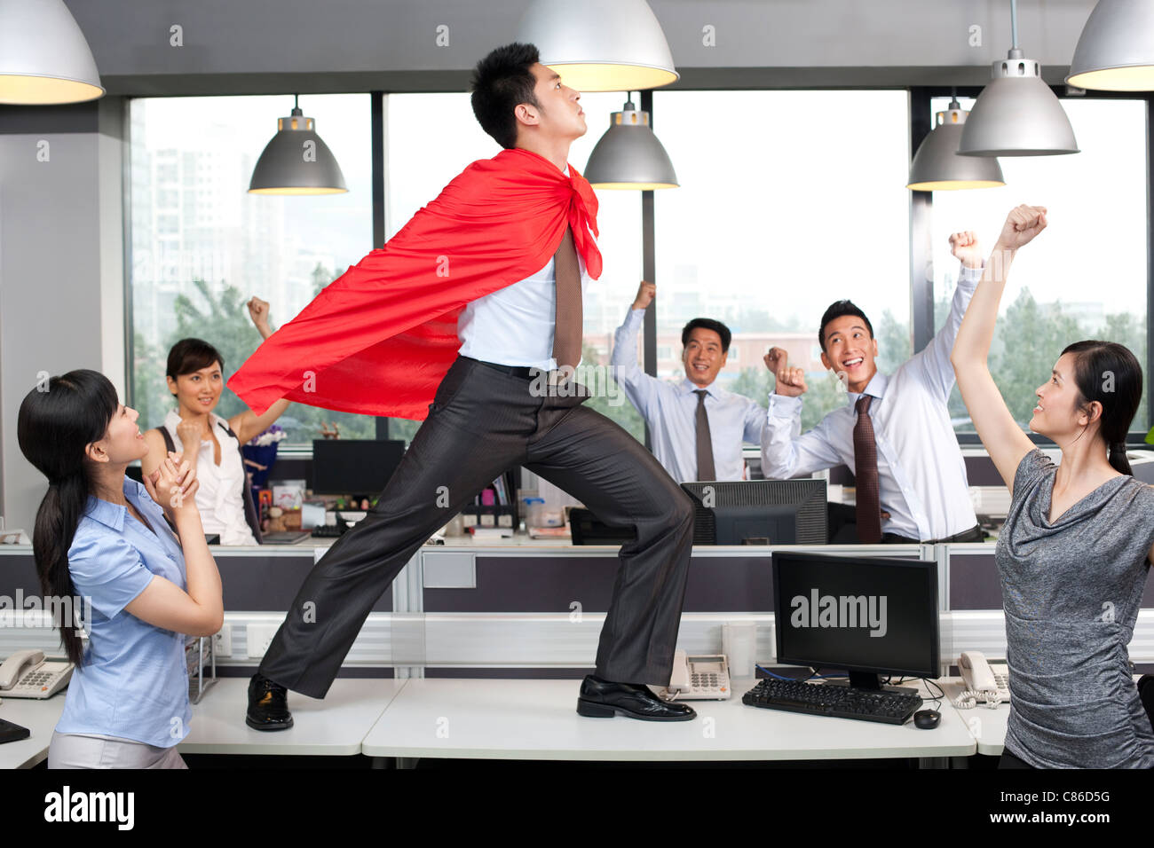 Colleagues Cheering On Superhero Stock Photo - Alamy