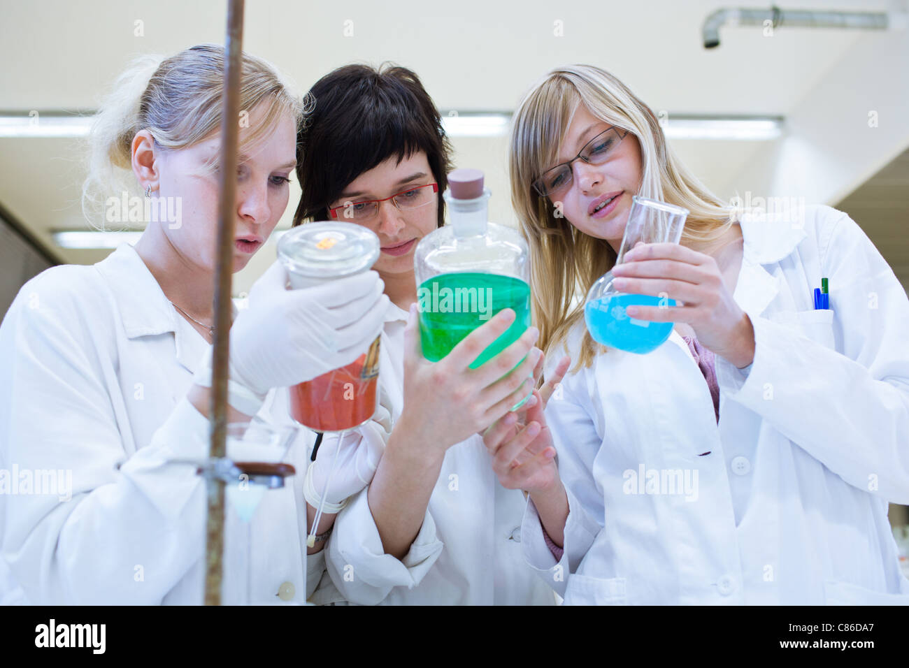 Three female researchers/chemistry students doing research in a ...