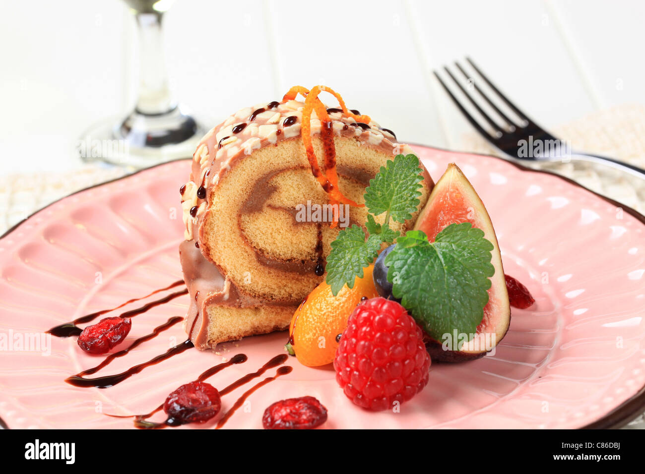 Slice of chocolate Swiss roll and fresh fruit Stock Photo - Alamy