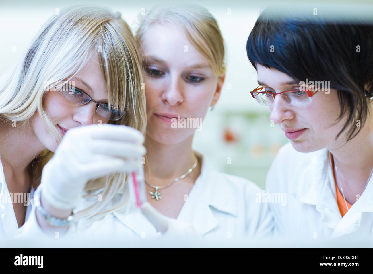 Three female researchers/chemistry students doing research in a ...
