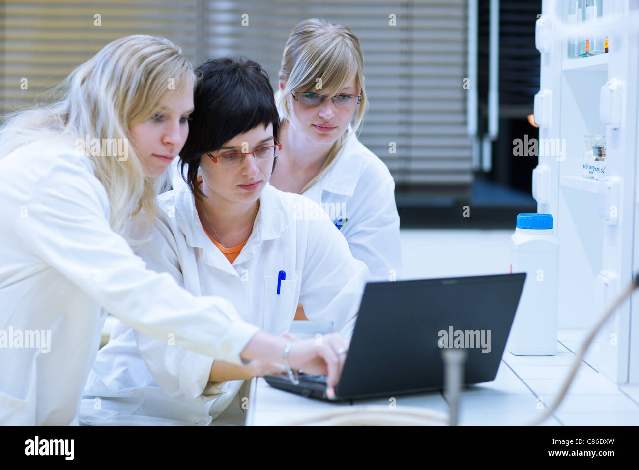 Three female researchers/chemistry students doing research in a ...