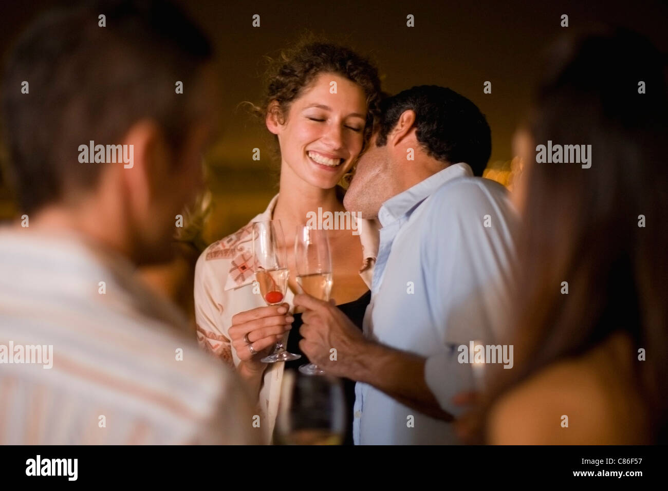 Couple kissing at party at night Stock Photo - Alamy