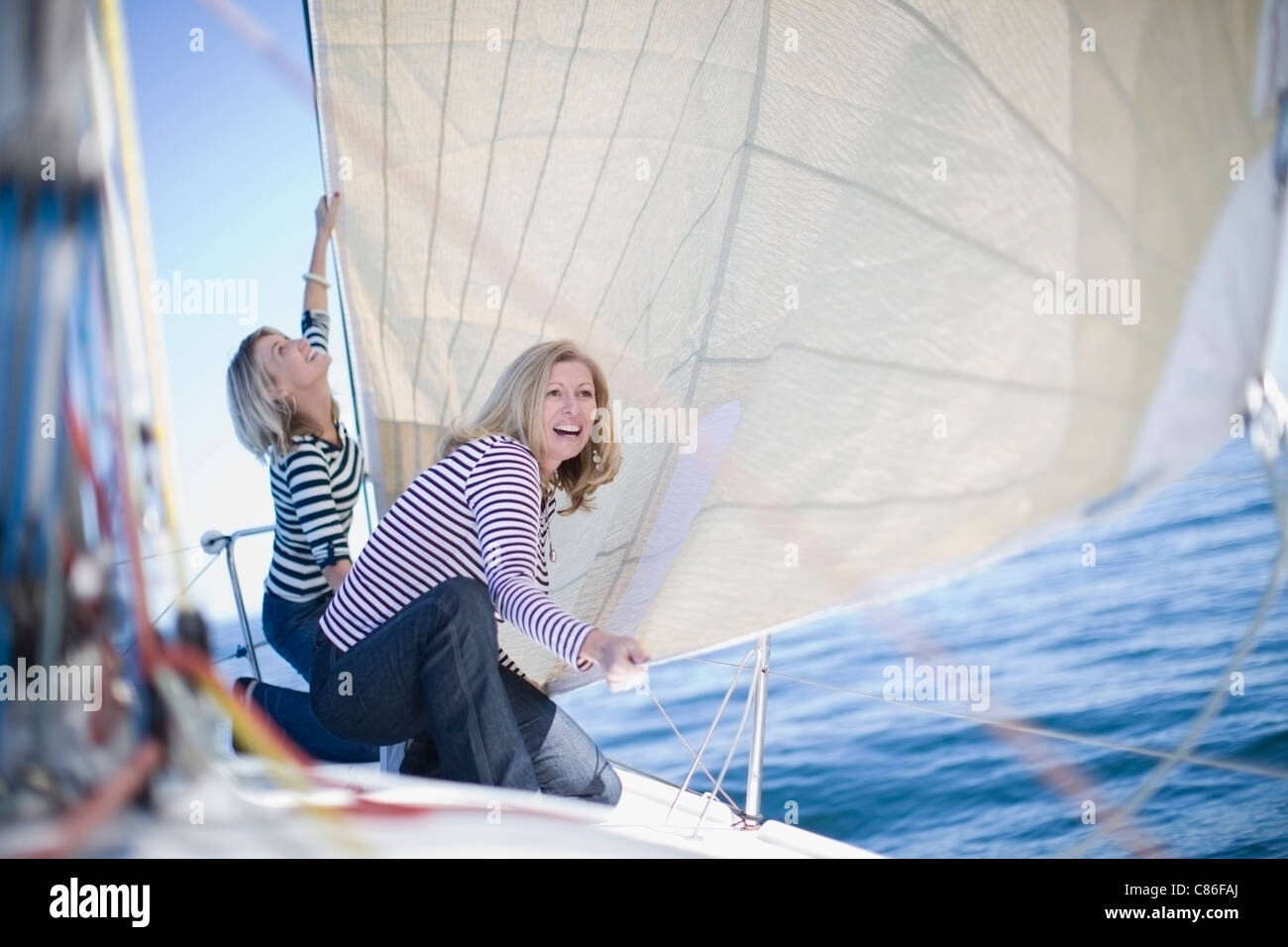 Women adjusting sail on boat Stock Photo - Alamy