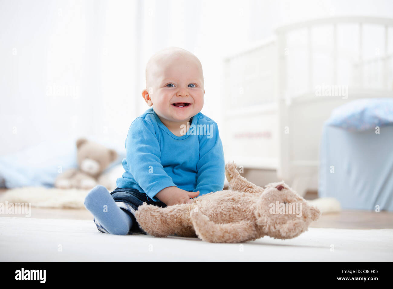 Baby boy playing with teddy bear Stock Photo - Alamy
