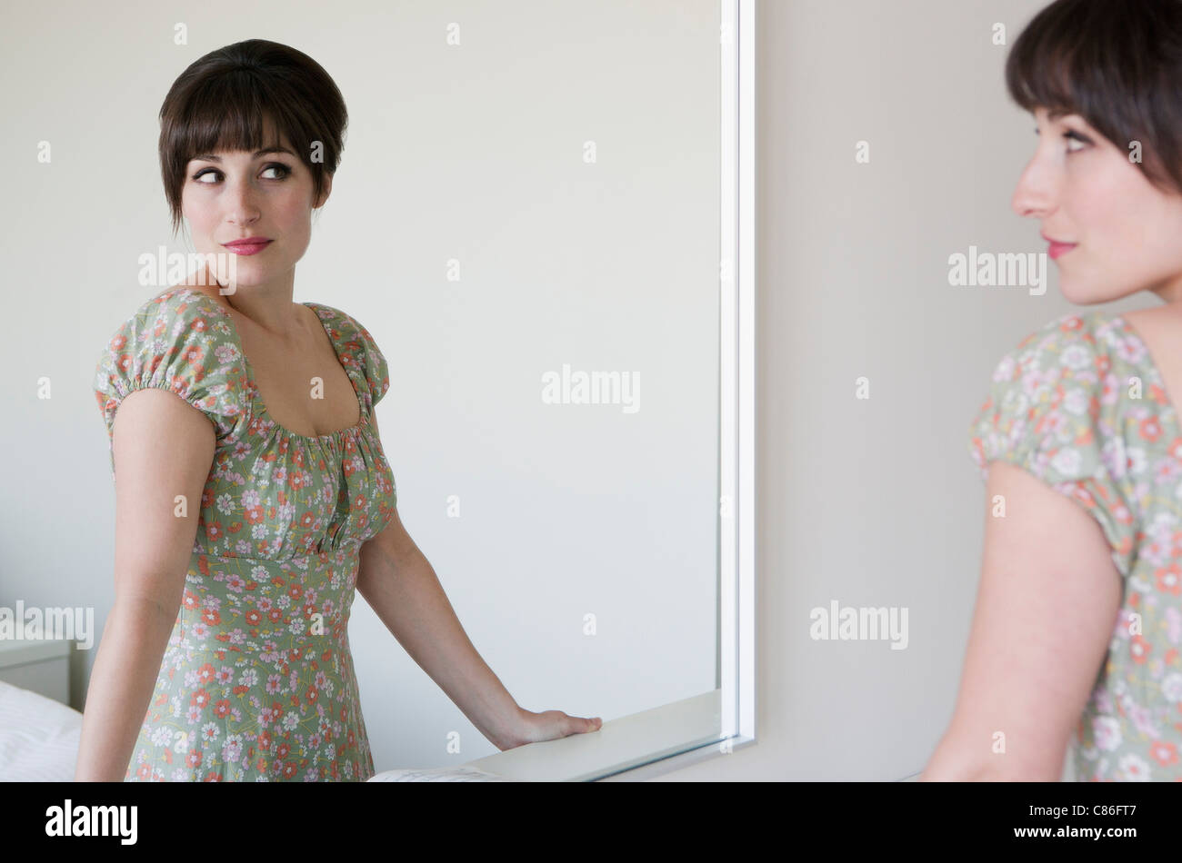 Woman admiring herself in mirror Stock Photo - Alamy