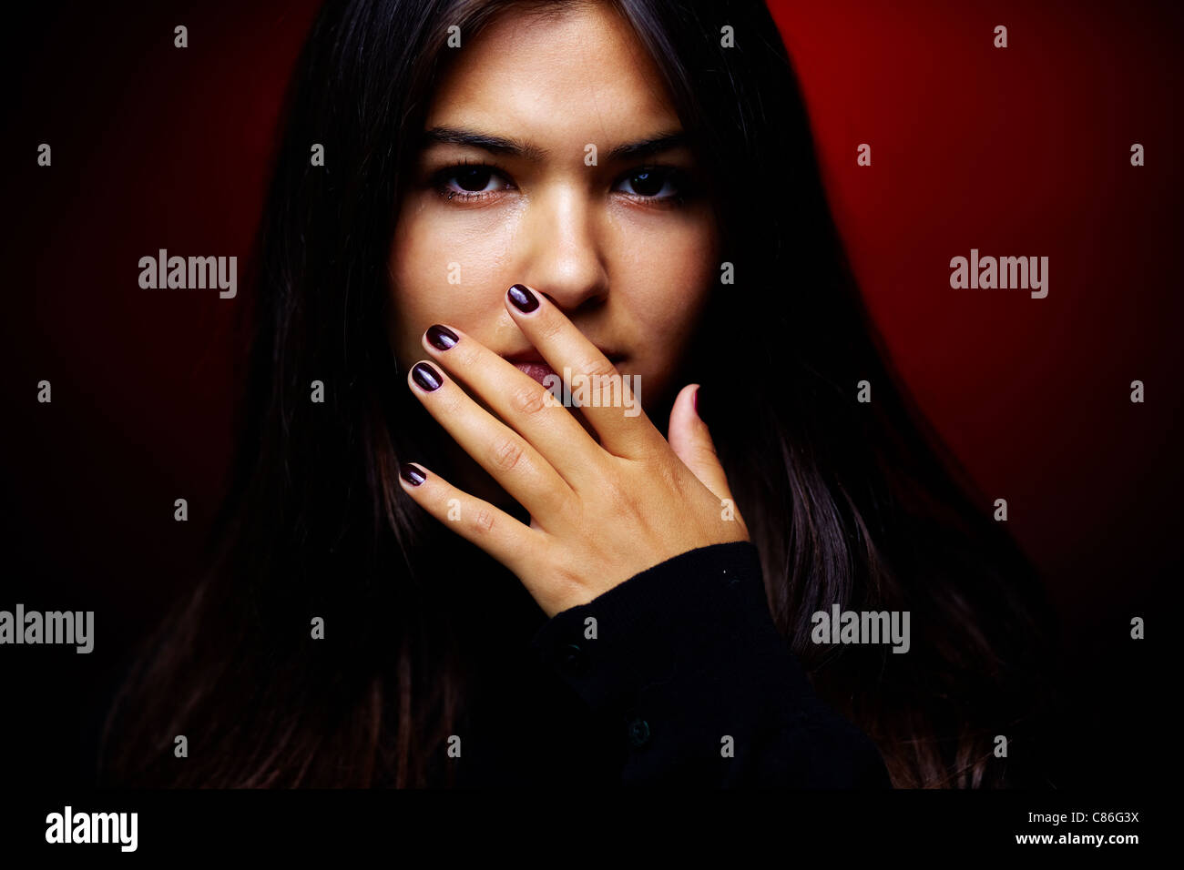 Young sullen woman looking at camera in the dark Stock Photo - Alamy
