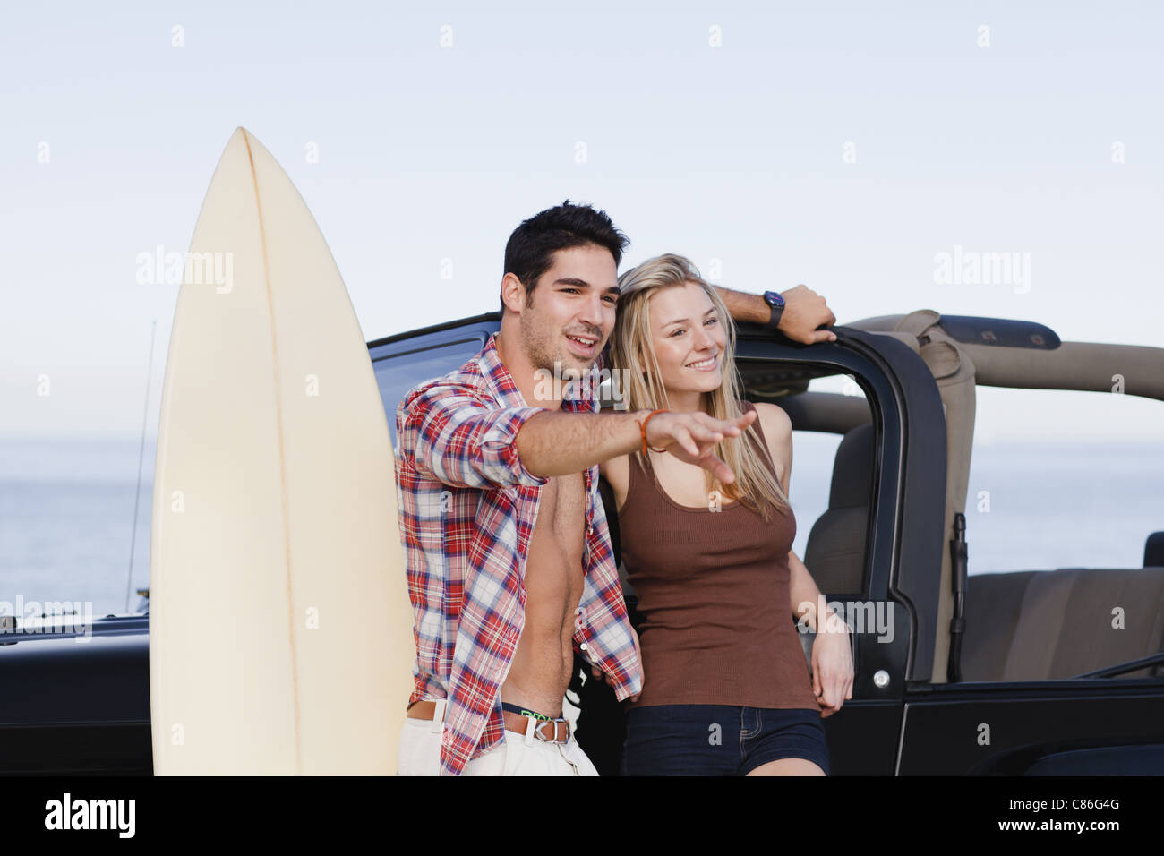 Smiling couple hugging by jeep Stock Photo - Alamy