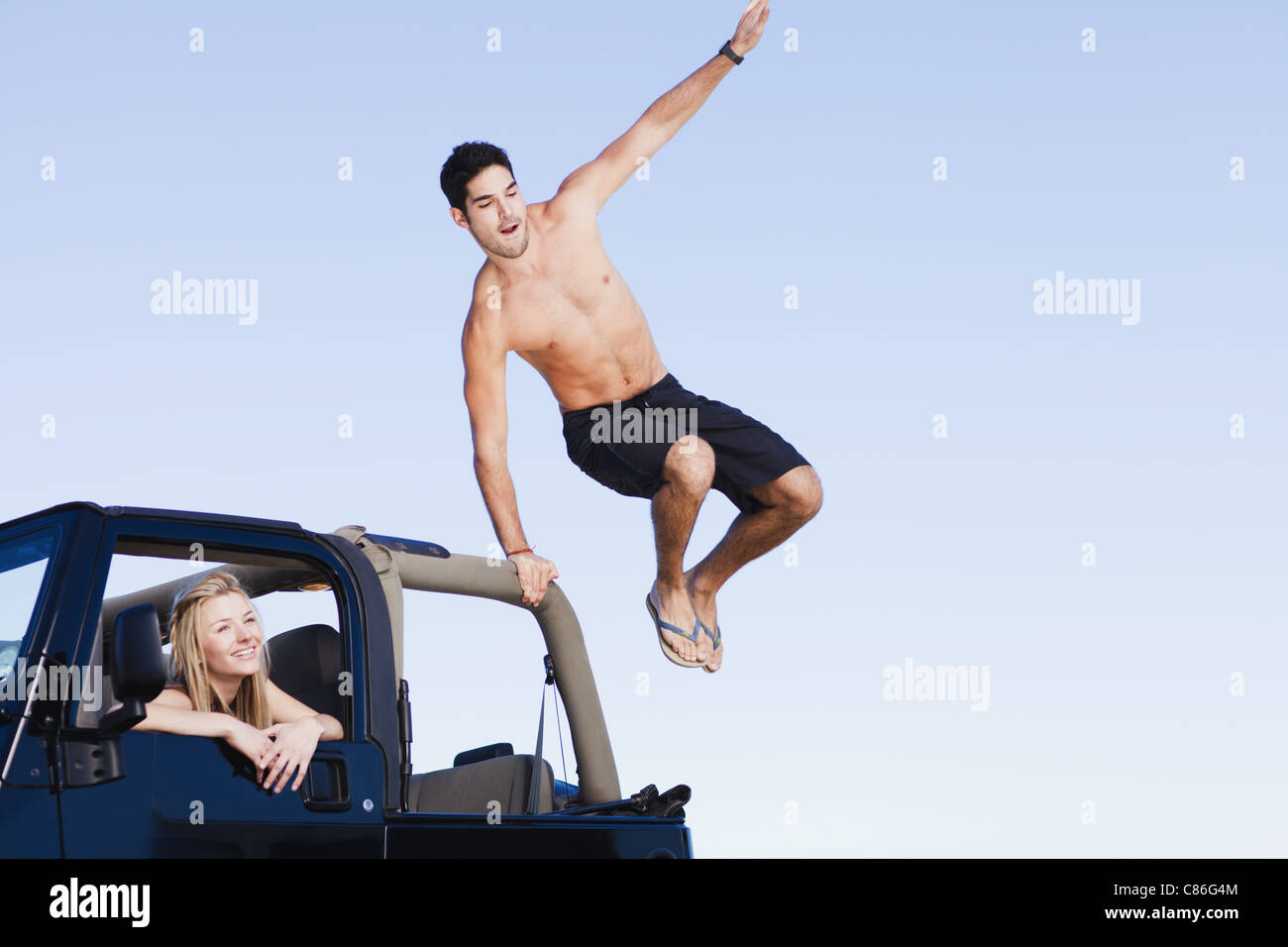Man jumping out of jeep Stock Photo - Alamy