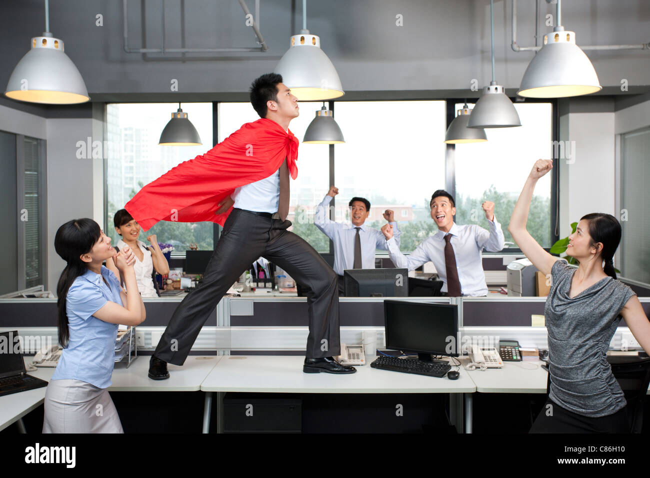 Colleagues Cheering On Superhero Stock Photo - Alamy