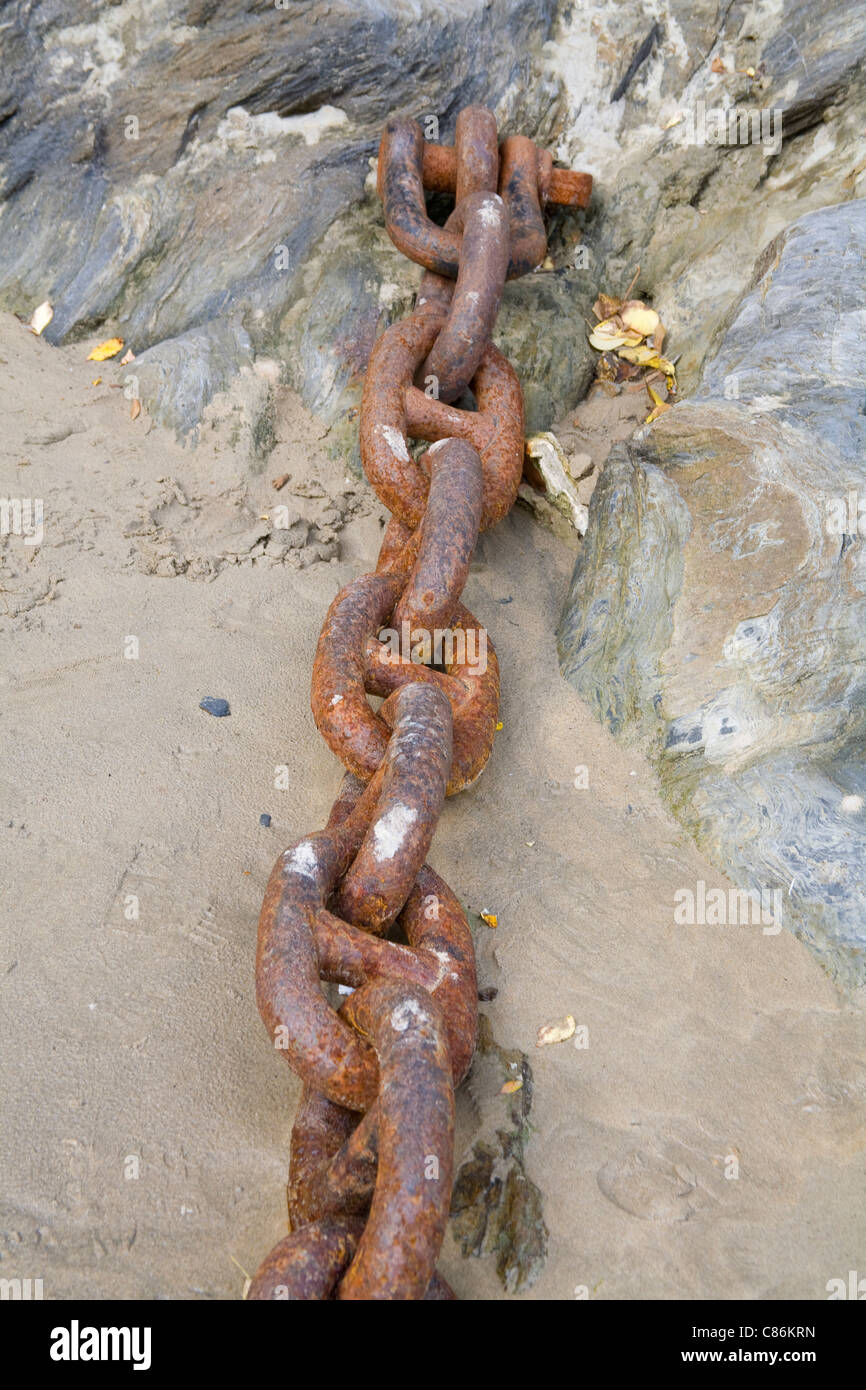 UK Rusty chain link attached to a rock and lying on sandy beach Stock ...