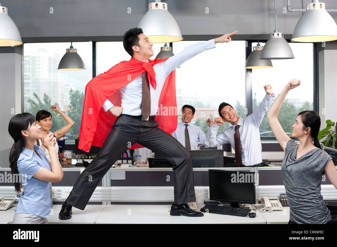 Colleagues Cheering On Superhero Stock Photo - Alamy