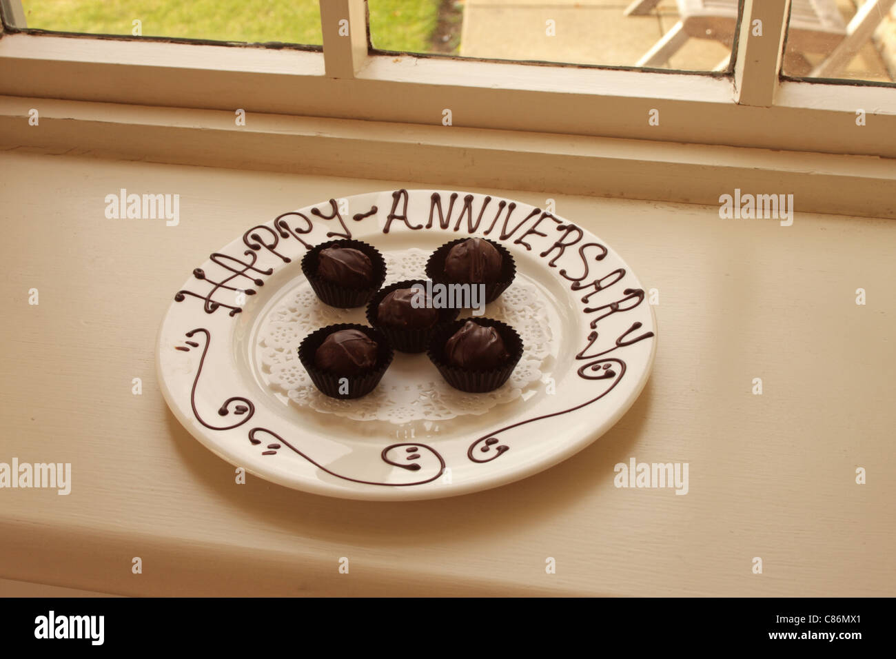 Happy Anniversary hotel welcome plate with chocolate truffles Stock ...