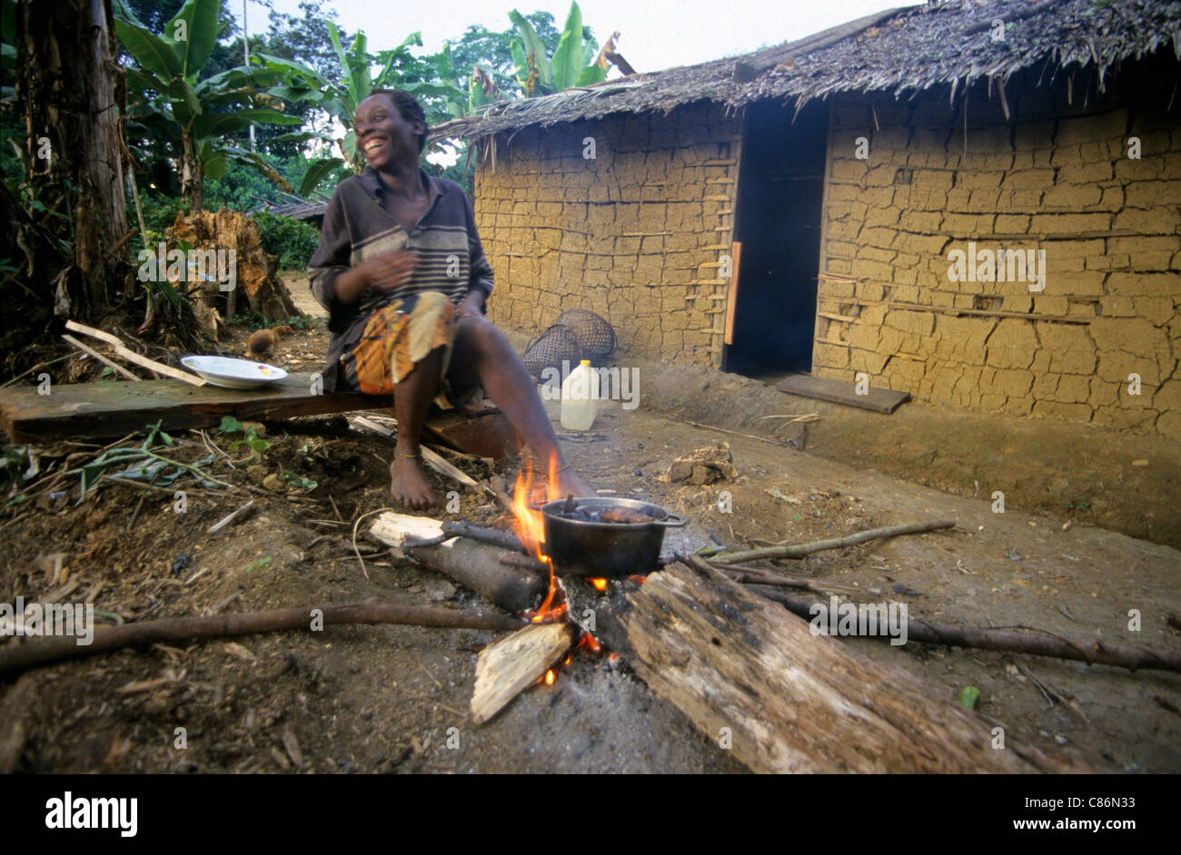 Woman cooking in a remote Pygmy village in the rainforest bordering ...