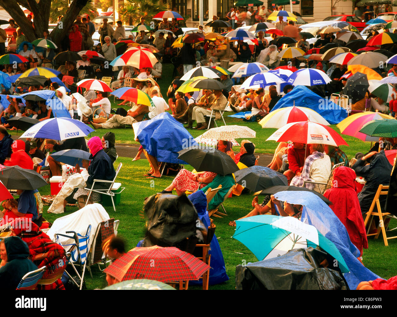 Family fun at outdoor concert sitting under colorful umbrellas on town ...