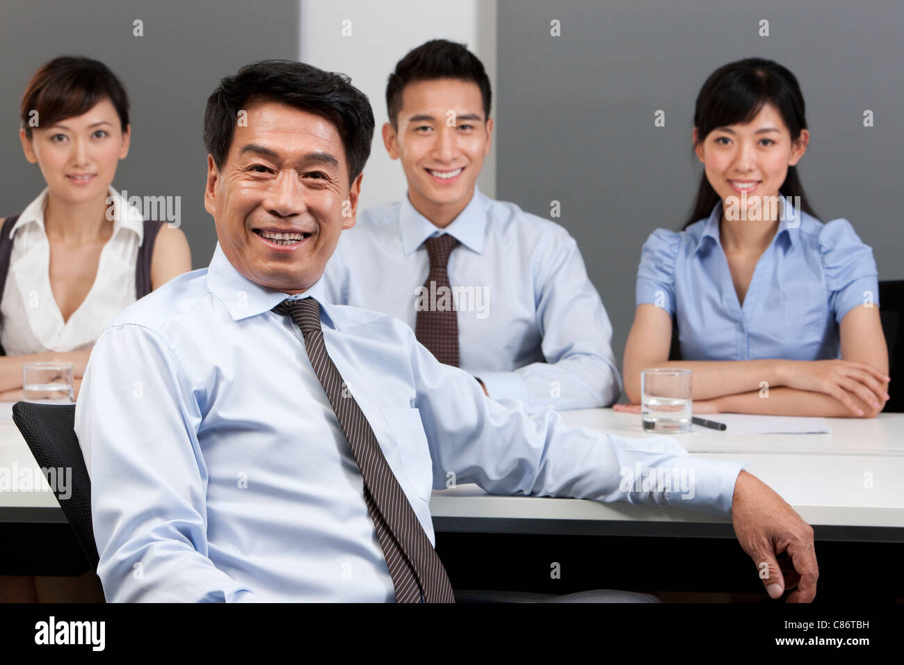 Colleagues Sitting Around a Conference Table Stock Photo - Alamy