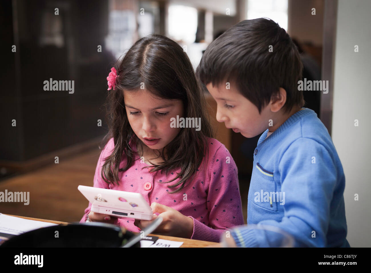 Siblings playing together on a DS Stock Photo - Alamy