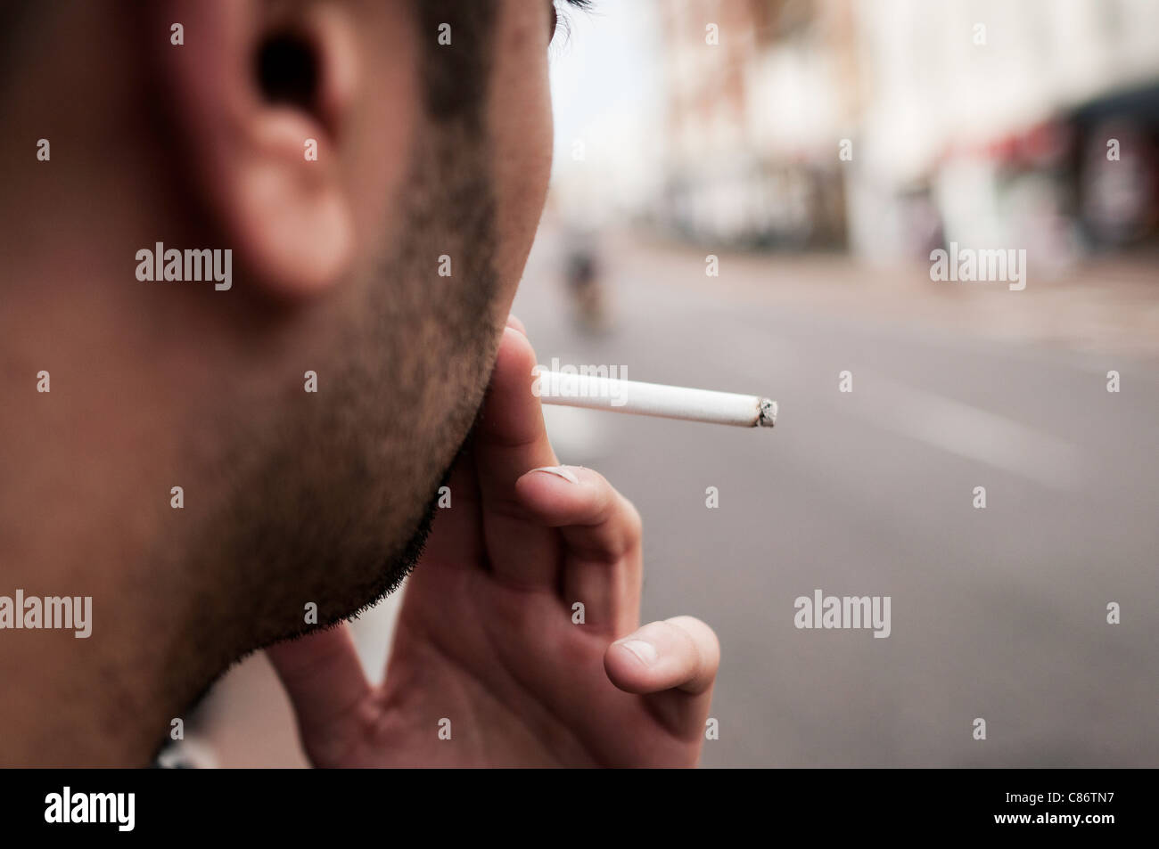 Young man smoking a cigarette Stock Photo - Alamy