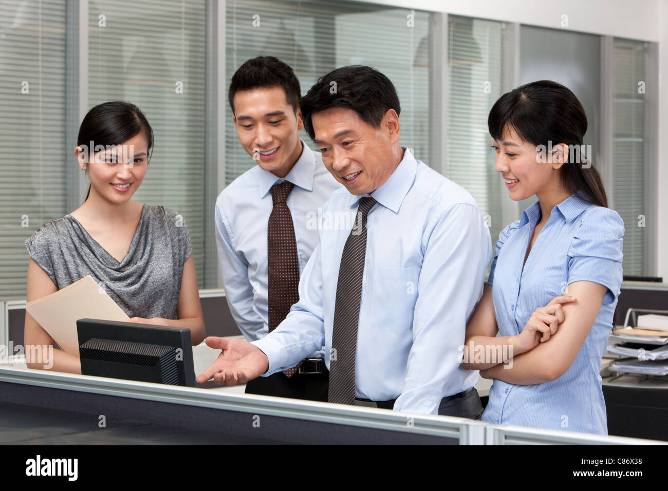 Senior Colleague Helping Co-workers Stock Photo - Alamy