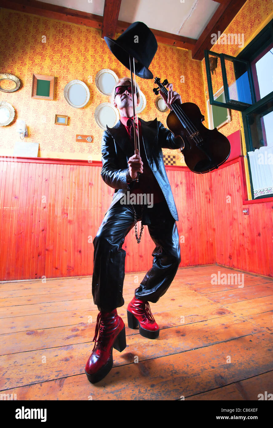 Violinist in funky red boots and leather cloth Stock Photo - Alamy