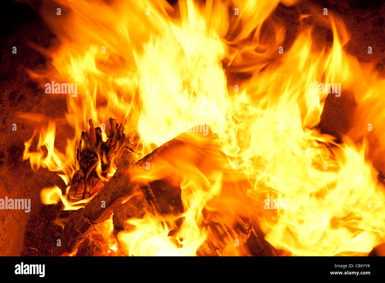 Close up of burning fire wood and flames. Image shows the charred wood ...
