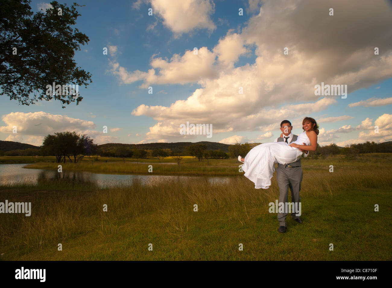 Groom carrying his bride at sunset Stock Photo - Alamy