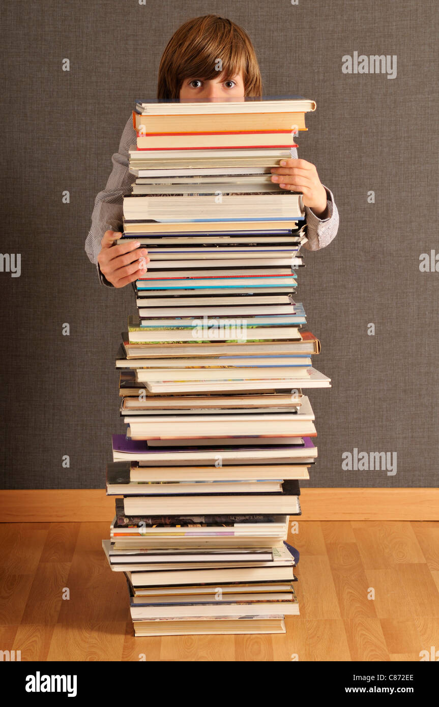 Boy Behind Stack of Books Stock Photo - Alamy