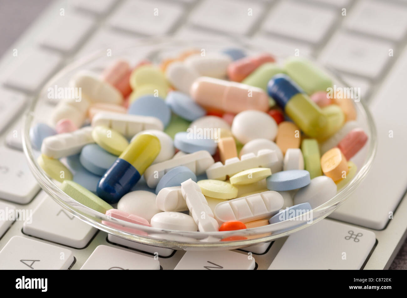 Dish of Pills on Computer Keyboard Stock Photo - Alamy