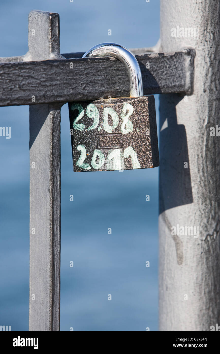 Metal padlock hanging on fence, close-up Stock Photo - Alamy