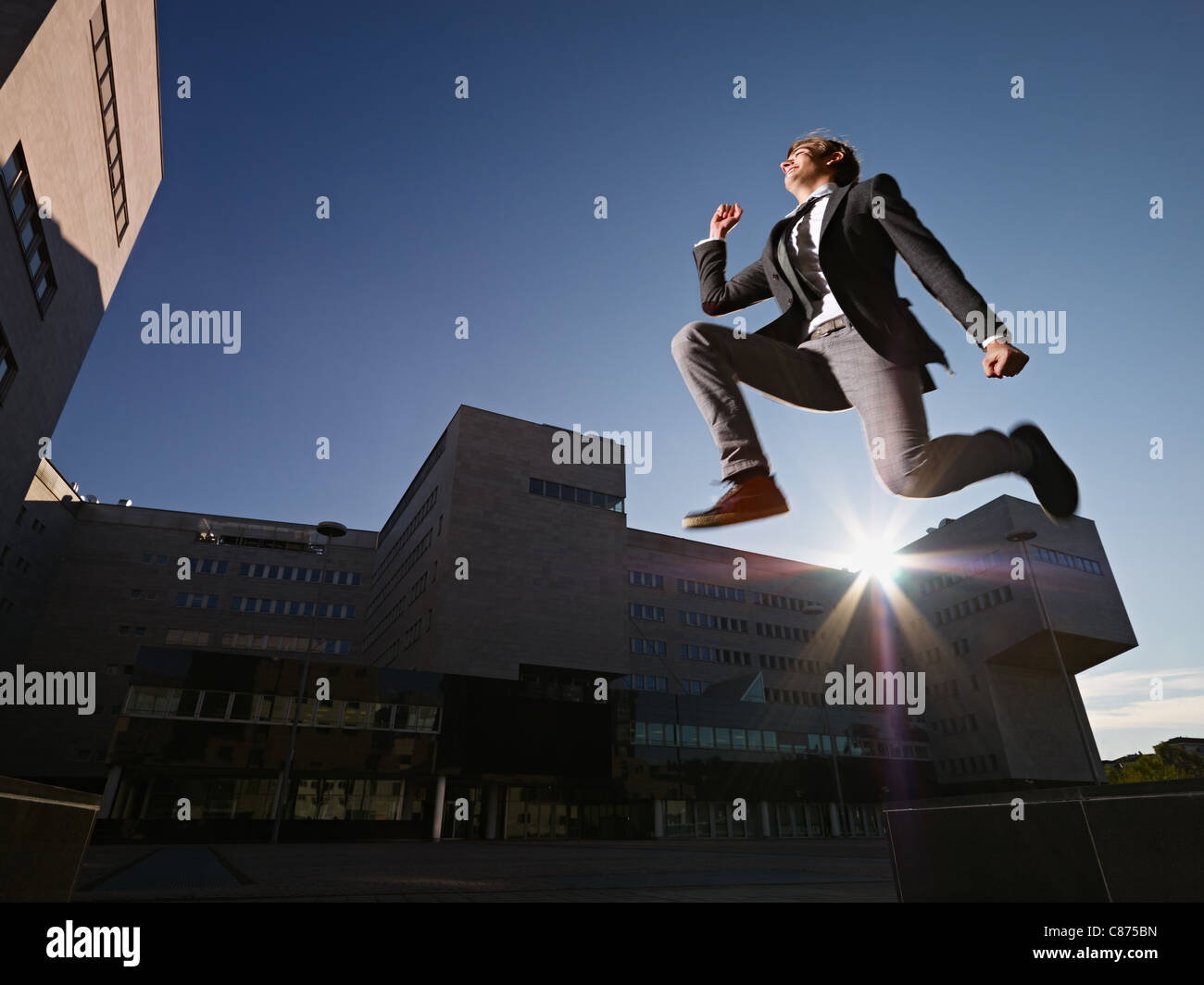 businessman jumping near office buildings Stock Photo - Alamy