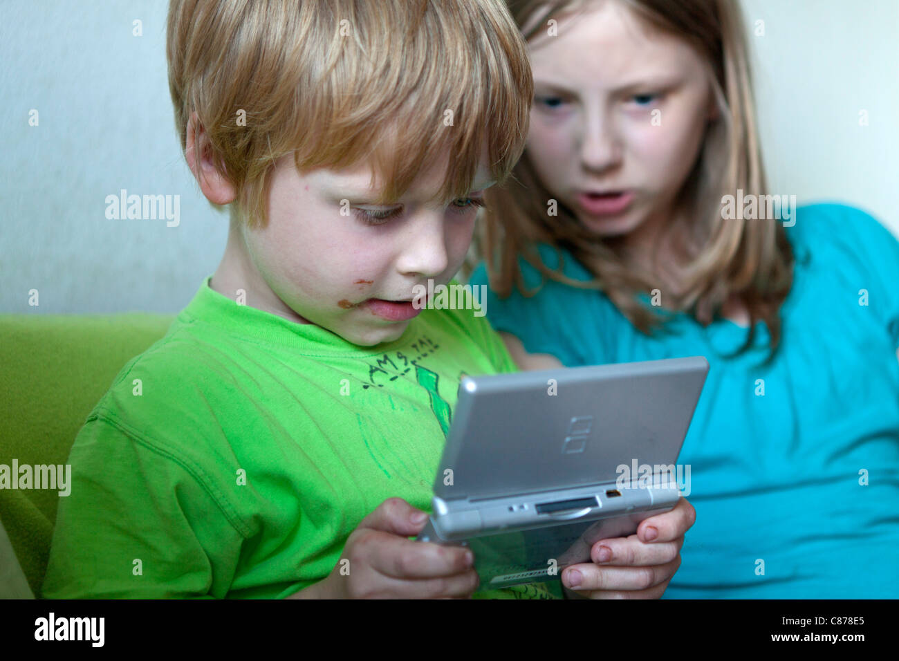 young boy playing Nintendo, girl watching Stock Photo - Alamy