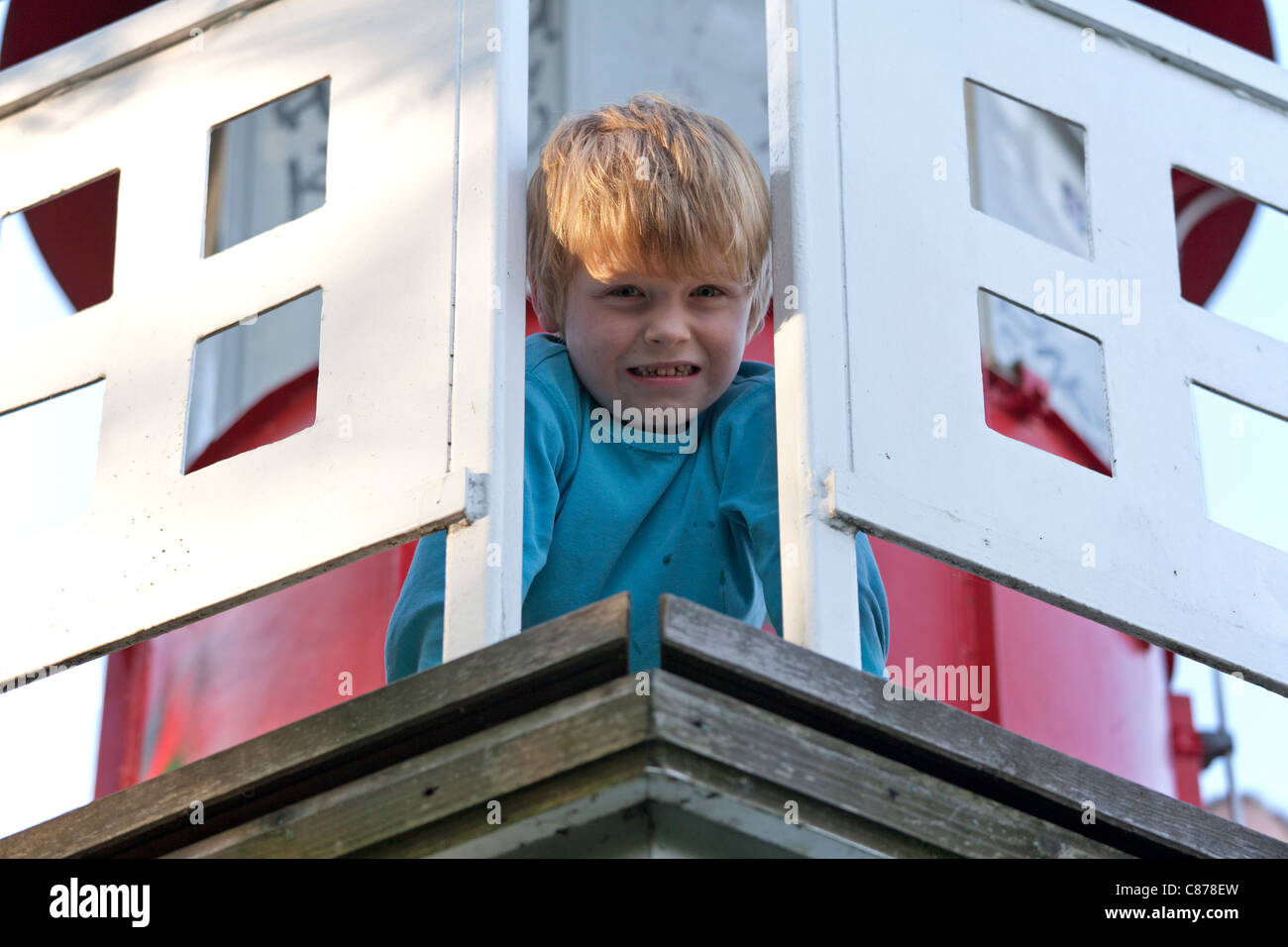 portrait of young boy looking through a fence Stock Photo - Alamy