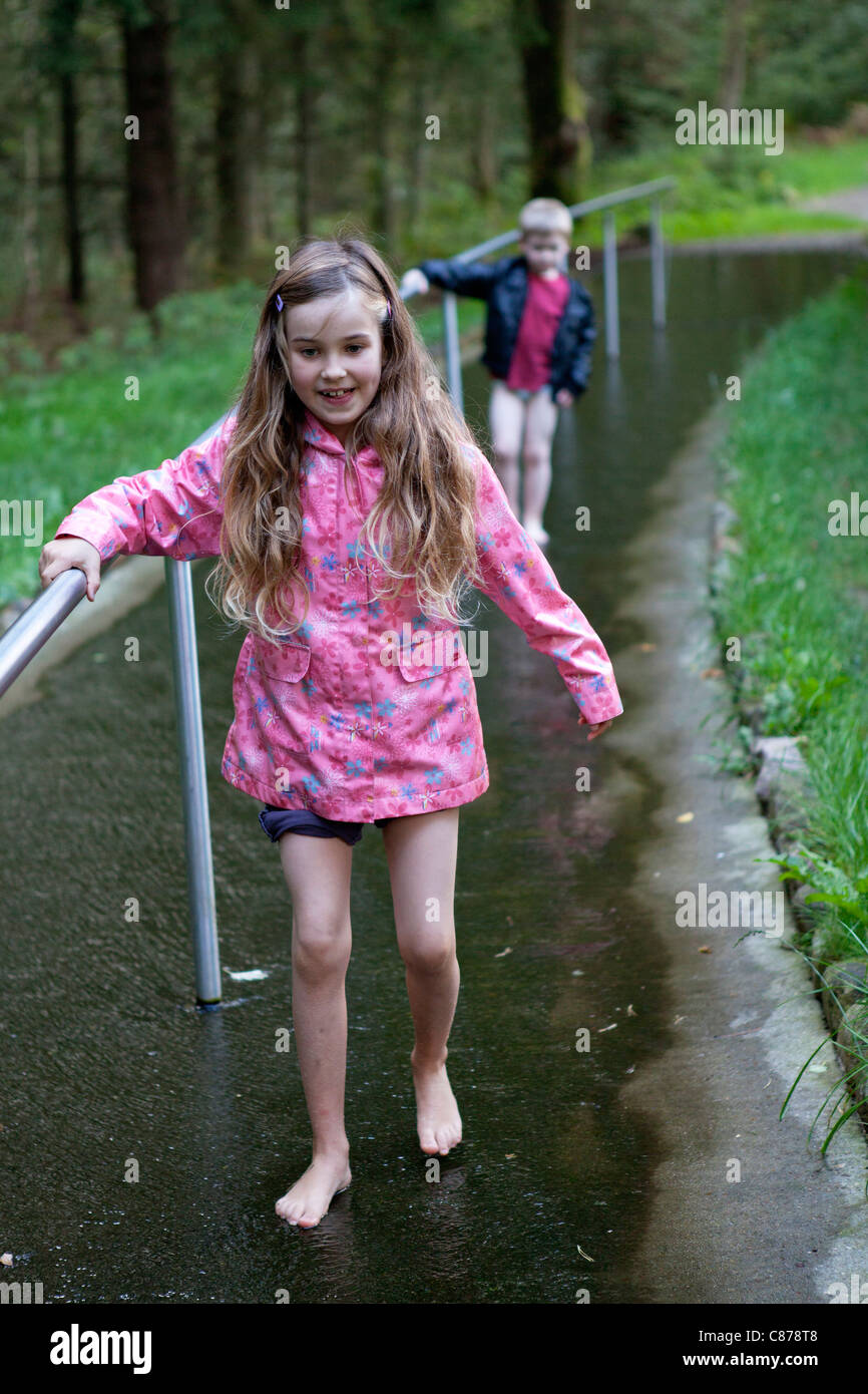 children walking barefoot through shallow water at barefoot park Stock ...