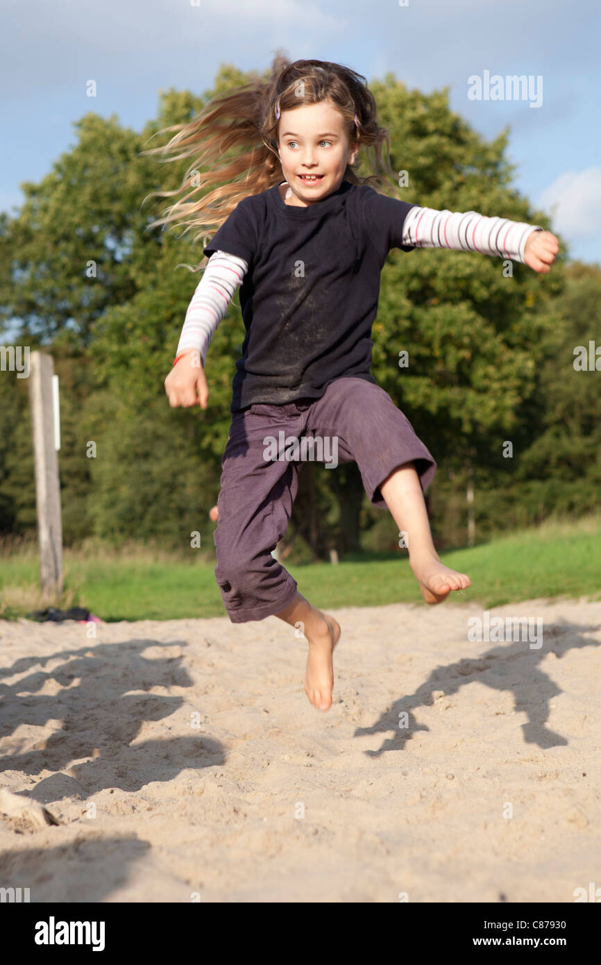 young girl doing a long jump Stock Photo - Alamy