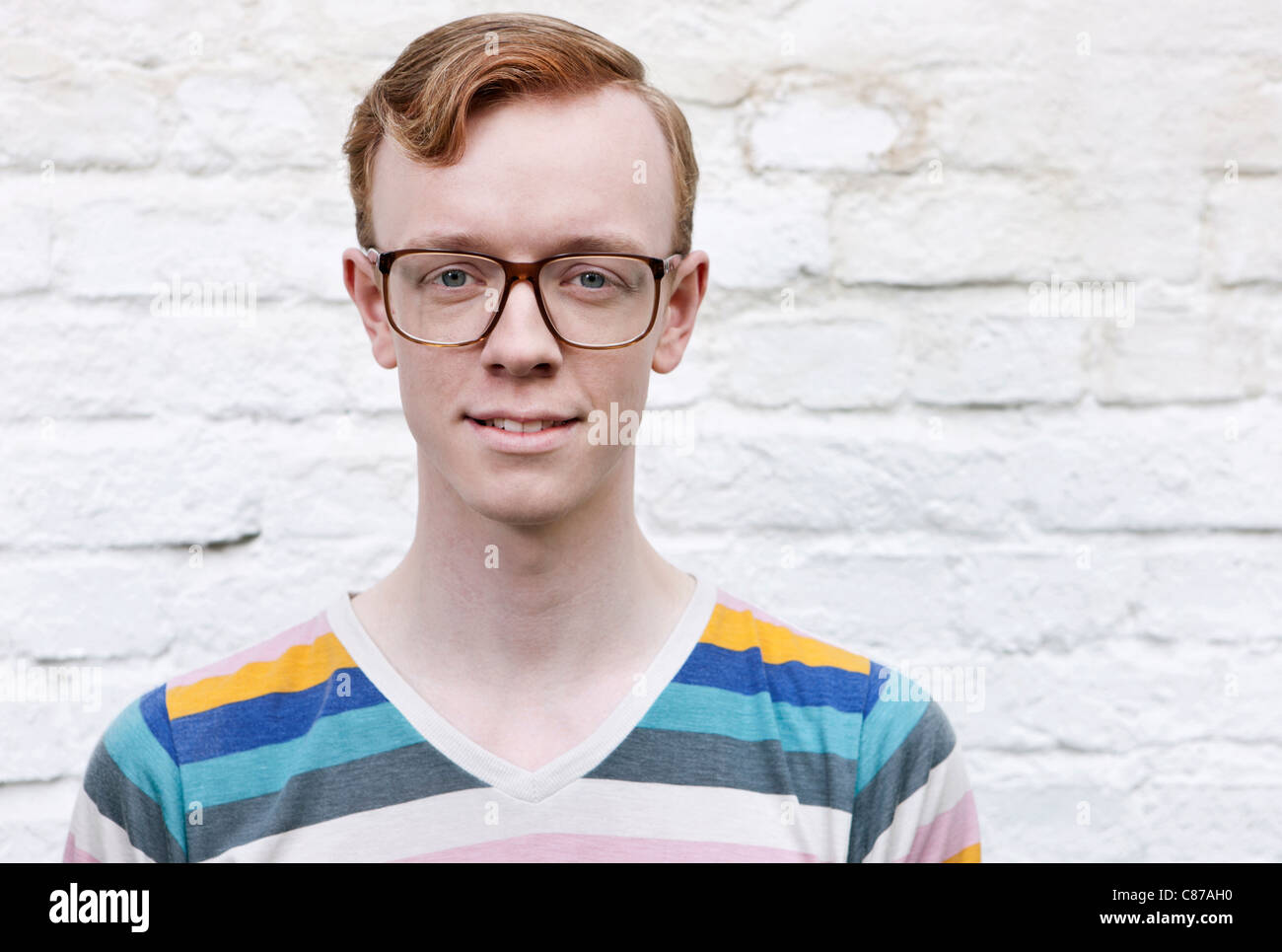 Germany, Berlin, Close up of young man with glasses, smiling, portrait ...
