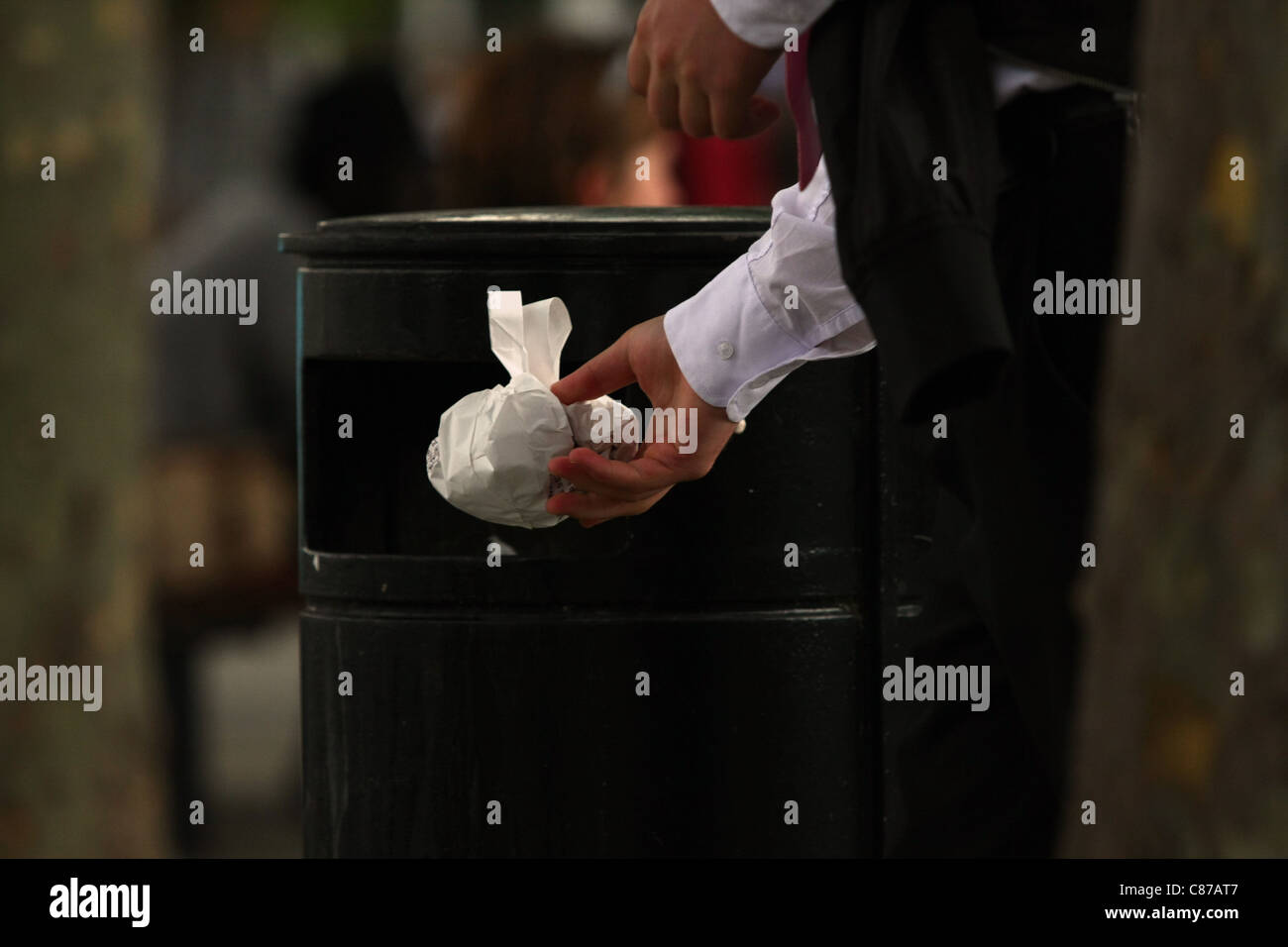 an arm putting rubbish into a public litter bin Stock Photo - Alamy