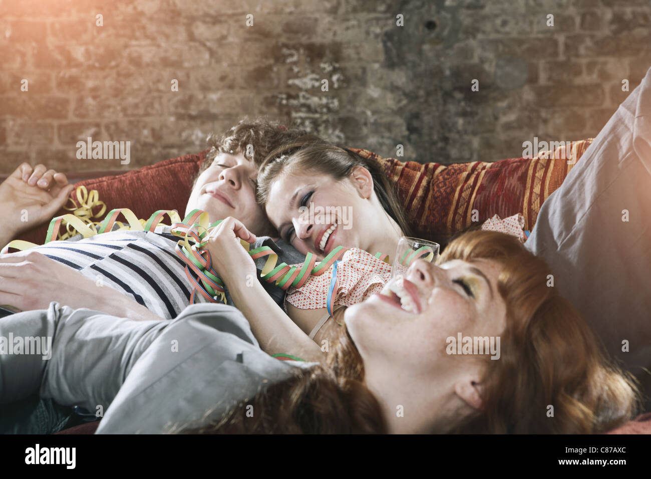 Germany, Berlin, Close up of young man and women relaxing on couch ...