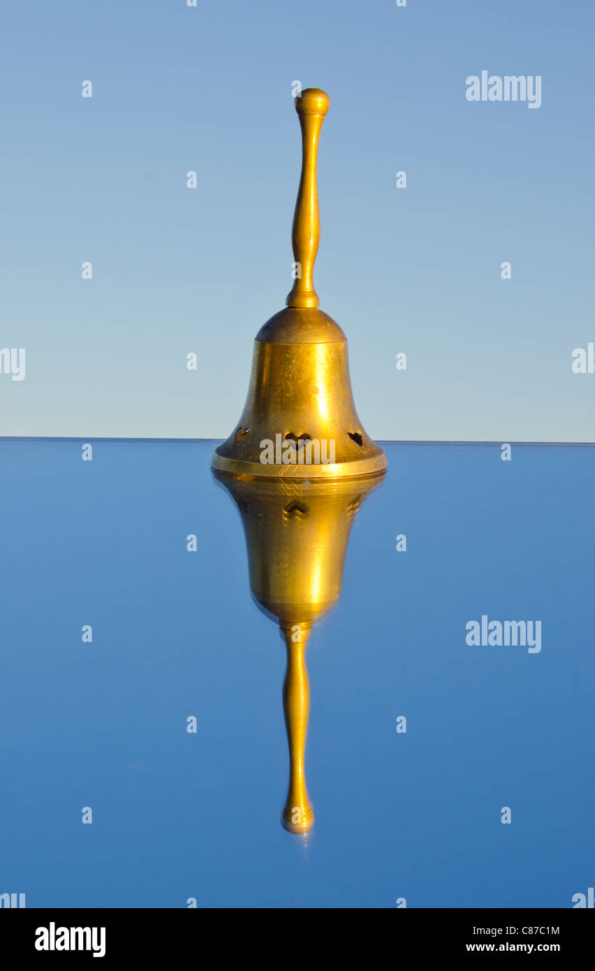 vintage brass bell on mirror and reflection Stock Photo - Alamy