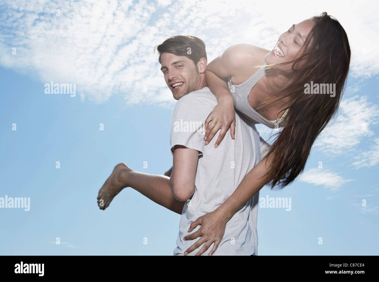 Spain, Majorca, Young man carrying woman on shoulders Stock Photo - Alamy