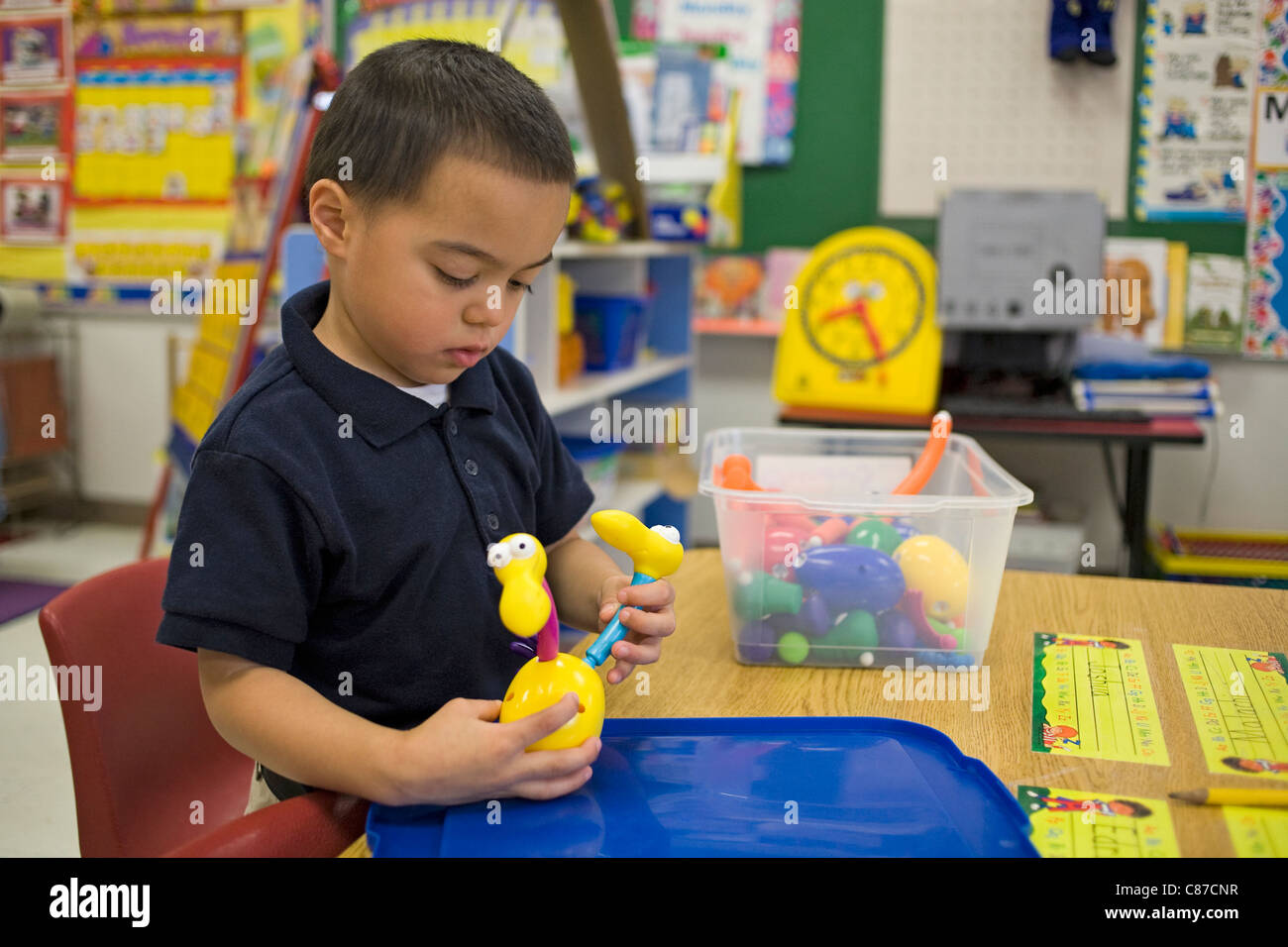 4 year old Caucasian preschool boy playing with a toy on a table in the ...