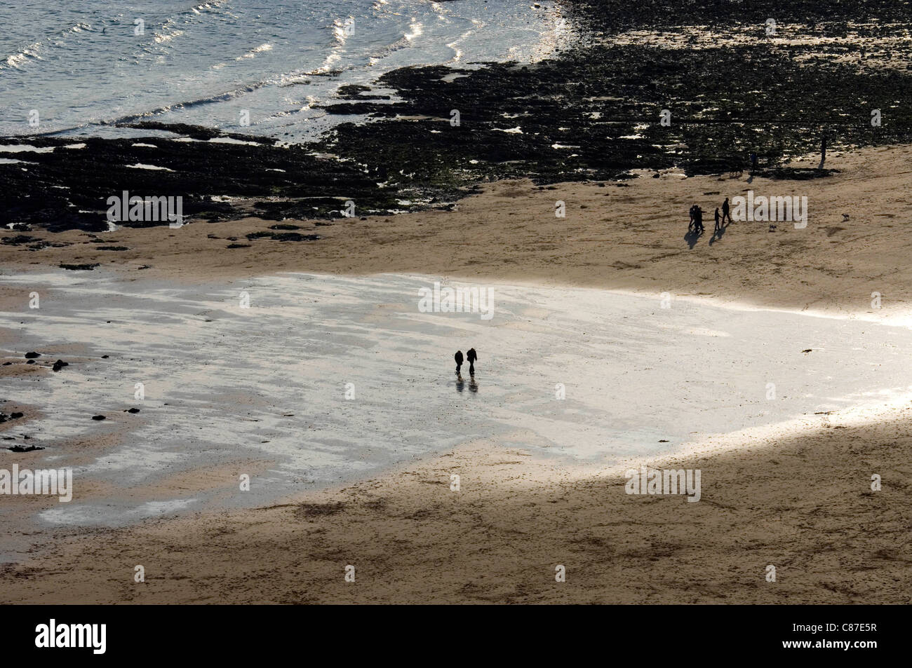 People making the most of the late afternoon sunshine at Langland Bay ...