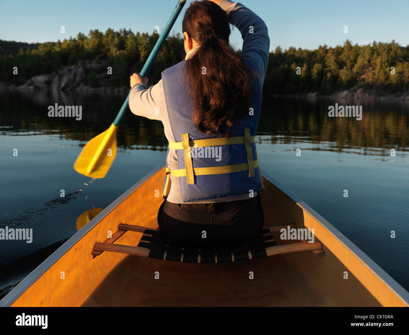 Woman paddling a canoe. Sunset fall nature scenery. Killarney ...