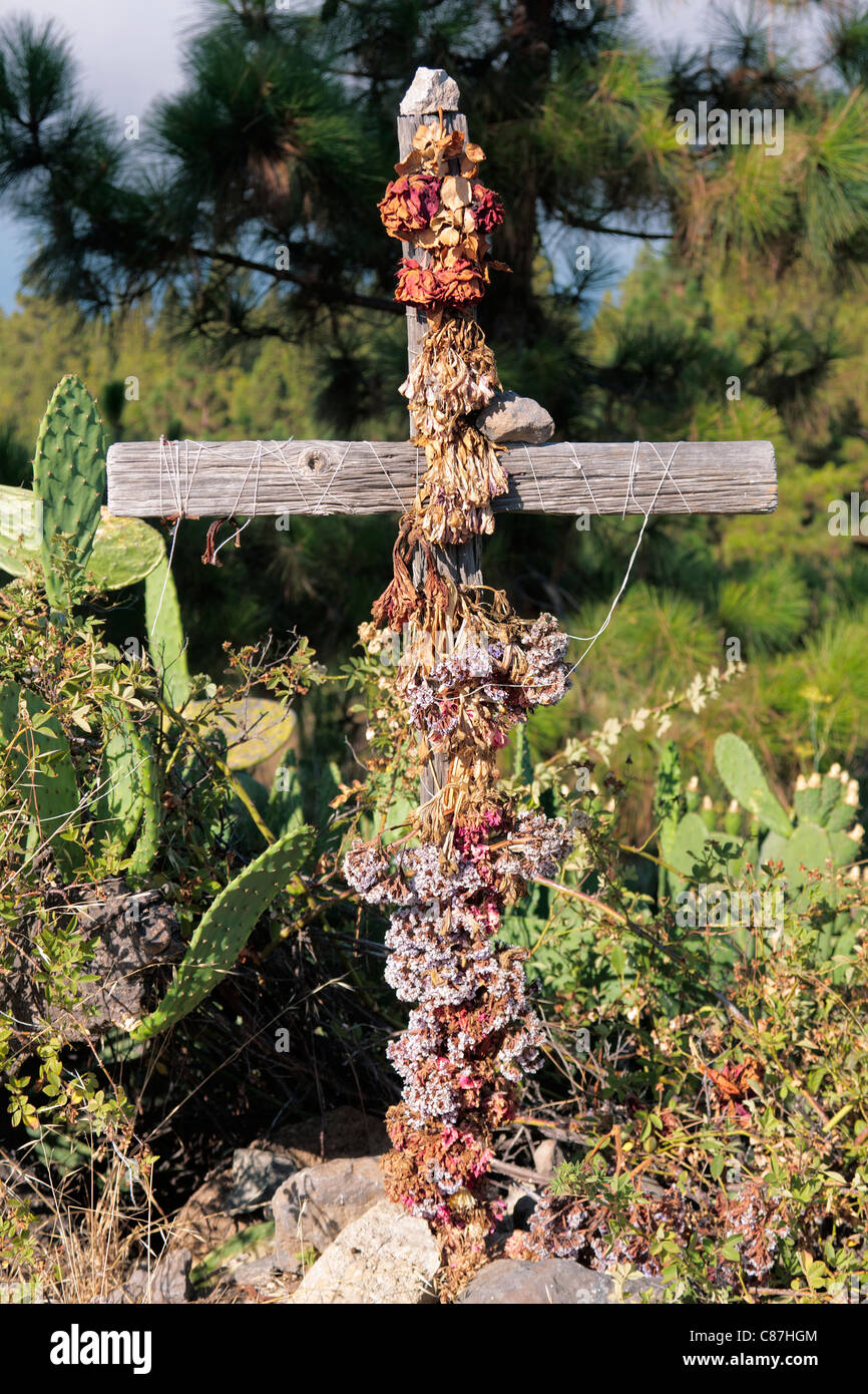 Wooden cross with dead flowers at the side of a path in Arona, Tenerife ...