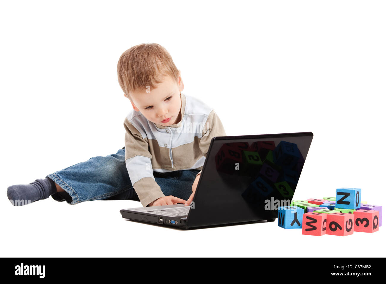 Preschooler boy learning to read using kids blocks and notebook ...