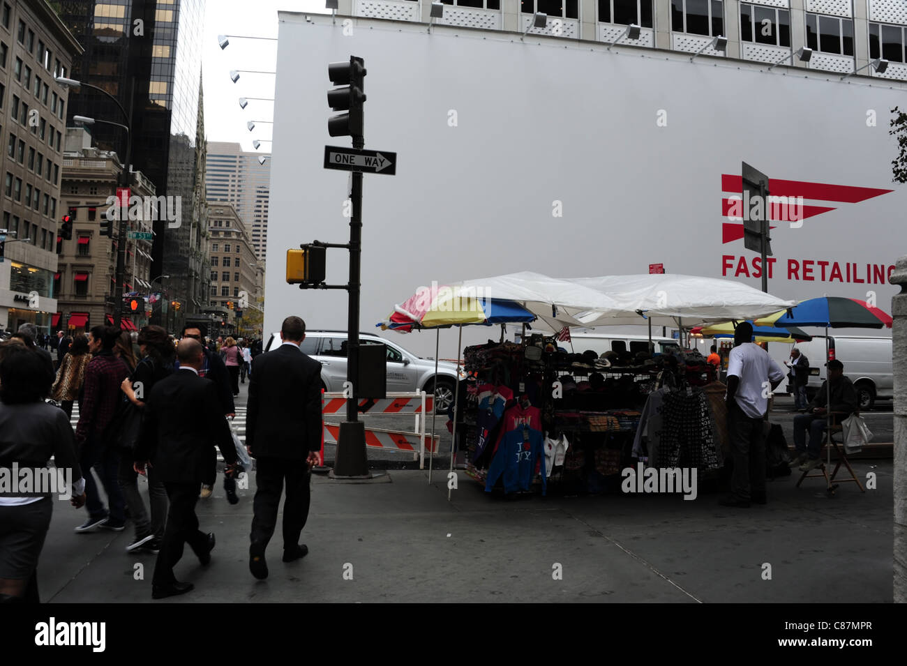 People walking by a street vendor market stall selling clothes, looking ...