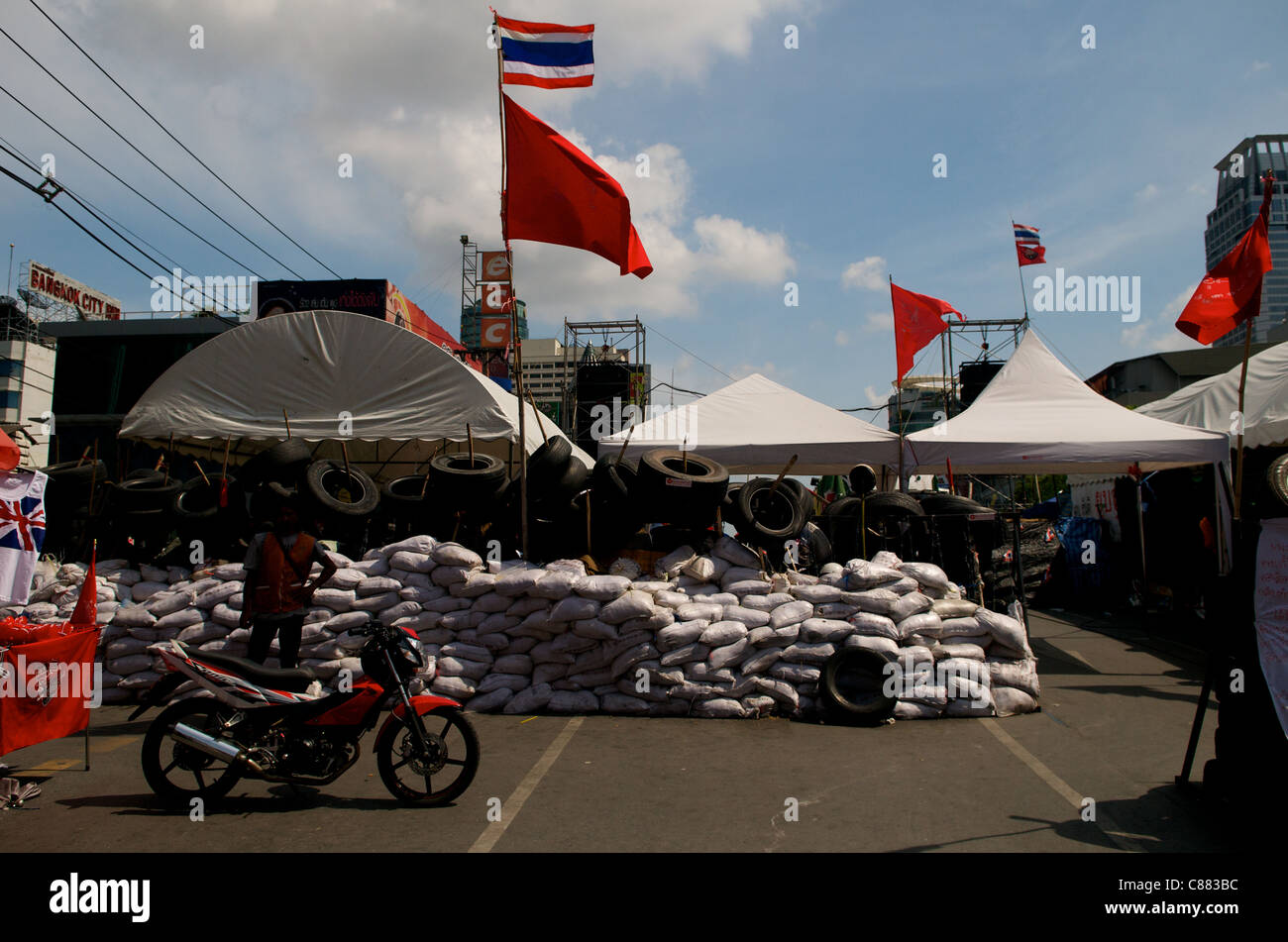 Thai flag above Barricade made of tires, bobwire, sandbags & sharpened ...