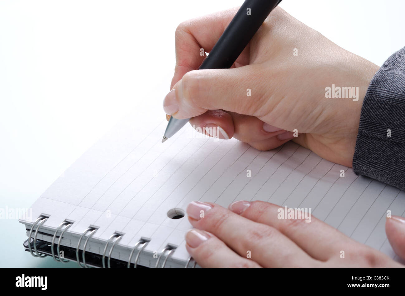 woman's hand with a pen on a notebook Stock Photo - Alamy