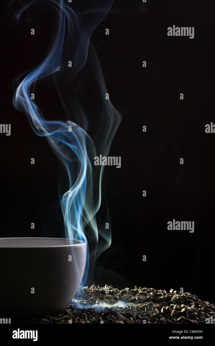 Tea and blue smoke on black background Stock Photo - Alamy